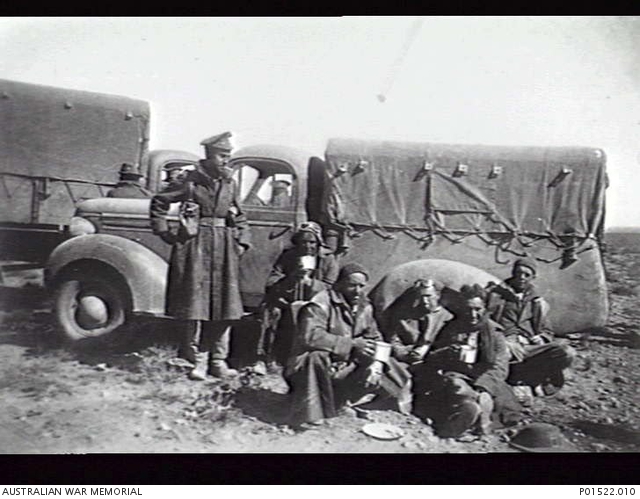 LIBYA. 1941-01? MEMBERS OF 2/2ND FIELD WORKSHOP SHELTER BESIDE ONE OF ...