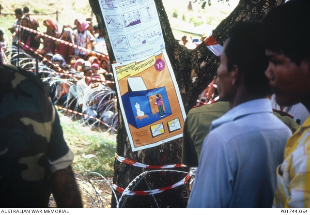 Cambodia, 1993-05-26. At a rural polling station, two Cambodians read ...