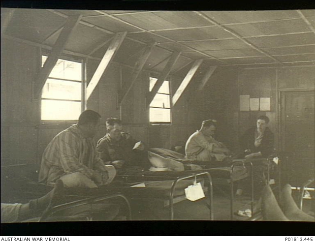 Pusan, Korea, c. 1951. Sick and wounded soldiers sit or lie on camp ...