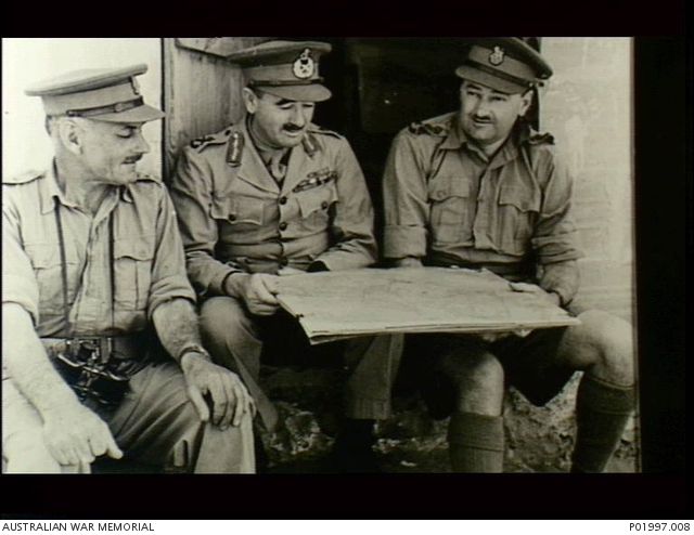 Tobruk, Libya. 1941-05. Consulting a map on the steps of a building ...