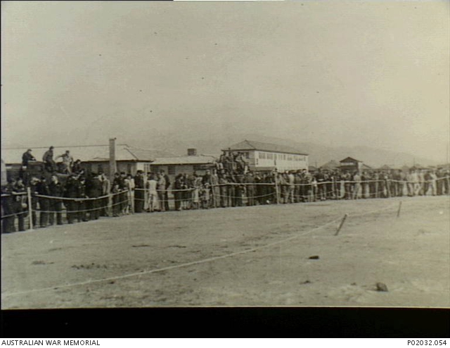 Bofu, Japan. 1948-01-04. Spectators crowd behind a fence next to the ...