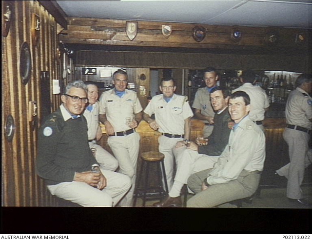 A group of United Nations Military Observers (UNMOs) sit on stools ...