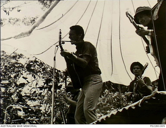 The Sydney entertainer Col Joye singing and playing guitar on a ...