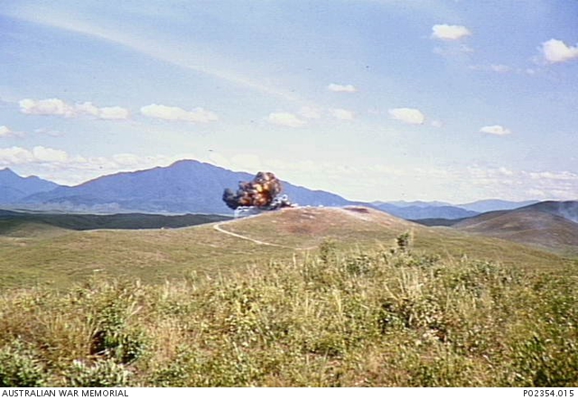 A cloud of smoke and flames rises from an exploding bomb dropped by a ...