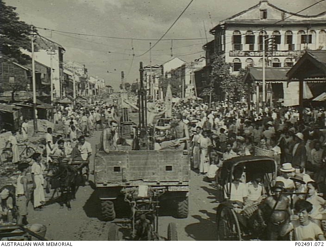 Rangoon, Burma. c. May 1945. A crowded Dalhousie Street, as light anti ...