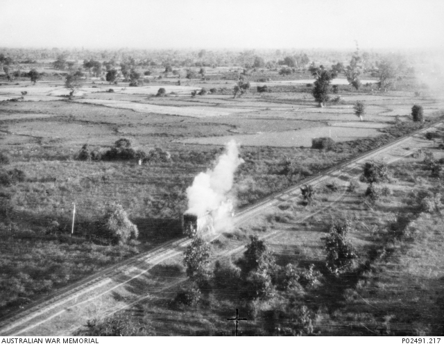 Kawlin, Burma. c. July 1944. A locomotive and wagon on the railway line ...