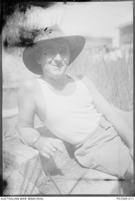 Informal portrait of Harry Russell, seated on the steps of the Selarang ...