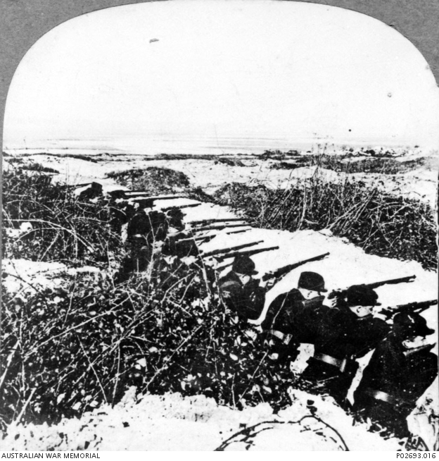 Allied soldiers lined up, aiming their rifles over the snow-covered ...