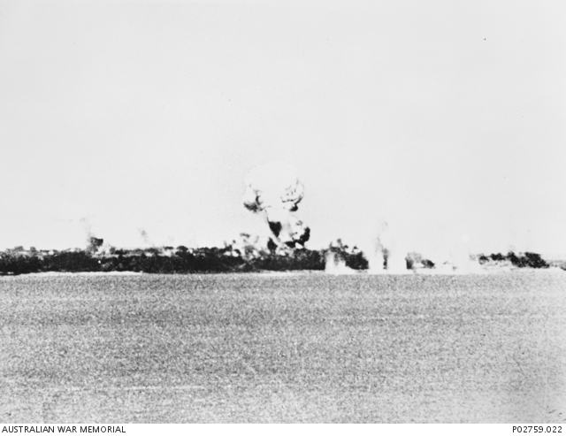 Bomb bursts in the sea near an oil tank on the waterfront exploding ...