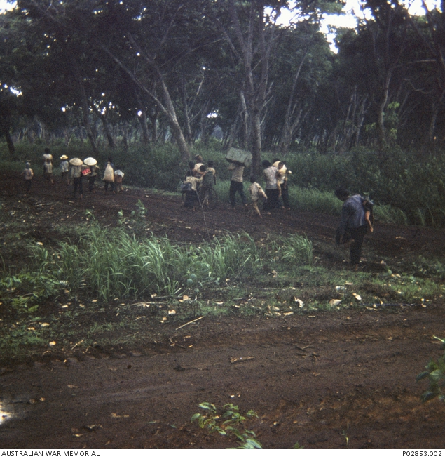 Villagers move up the road, leaving the village immediately before an ...
