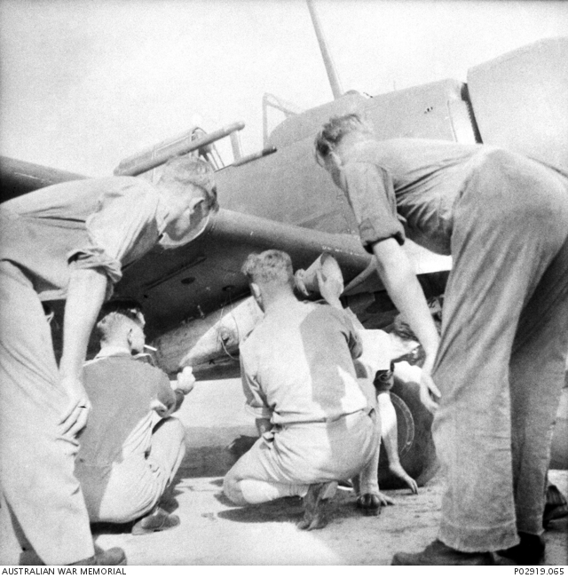 Canberra, ACT. January 1945. RAAF armourers fitting a smoke generator ...