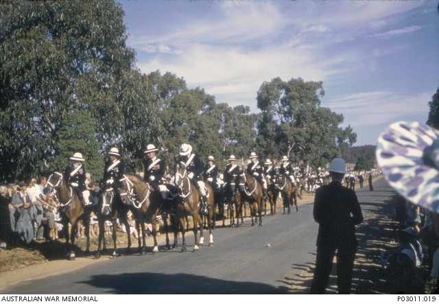 A parade of mounted Australian police officers ride four abreast on ...