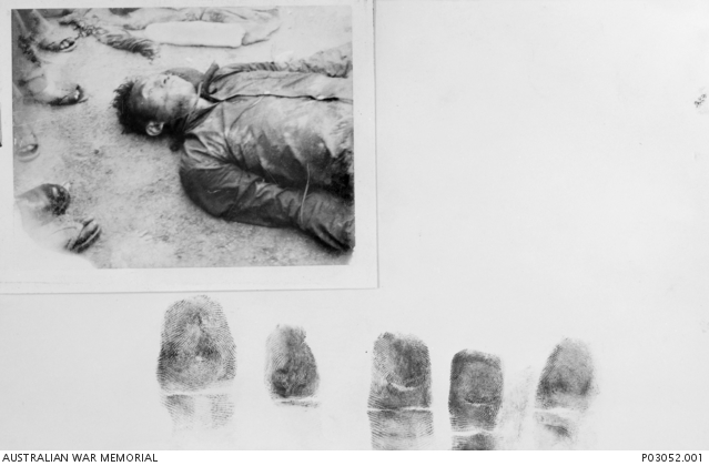A photograph of a dead male Viet Cong attached to a card showing his ...