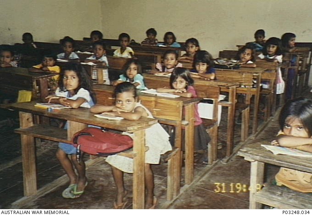 Dili, East Timor. 20 December 1999. Timorese children sitting at wooden ...