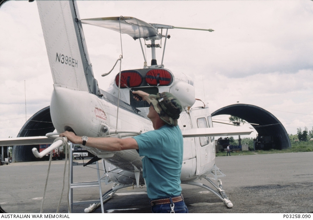 A pilot ties down the rotors on his Bell Twin 412 helicopter for the ...