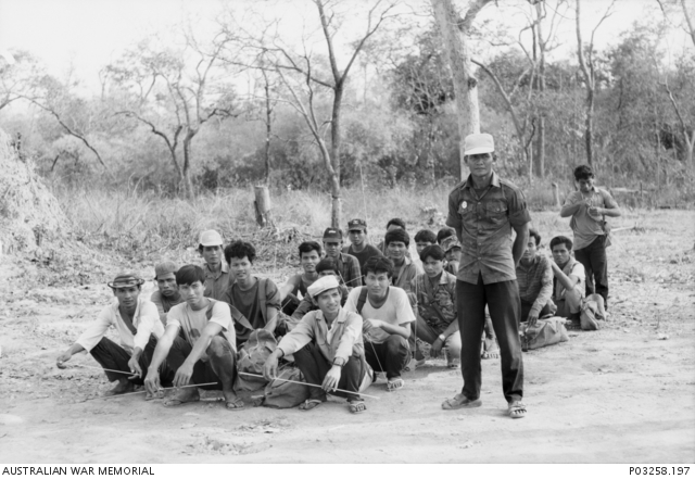A group of anti communist rebel soldiers squat in a group as they ...