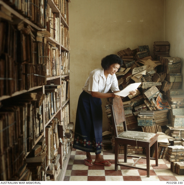 Lim Ki, manager of Cambodia's National Archives, checks papers in front ...