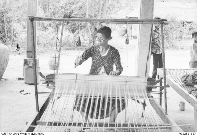 Following traditional practices, a silk weaver operates a loom to ...