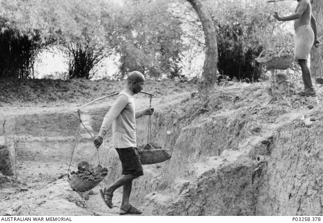 Loaded with two wicker baskets full of earth hanging from a carrying ...