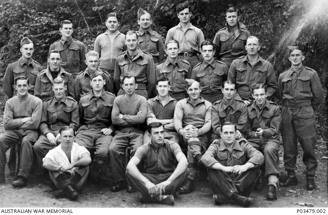 Outdoor group portrait of 24 prisoners of war (POWs) at a POW camp ...