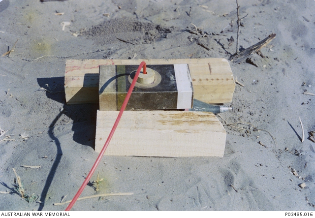 An unexploded ordnance device surrounded by pieces of wood and attached ...