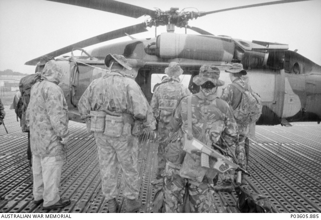 Pre-flight briefing of passengers in the rain, prior to a Black Hawk ...