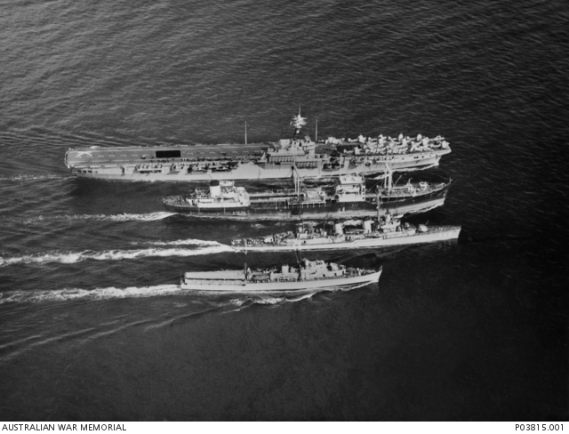 Aerial starboard side view of four Allied Navy ships in the ocean off ...