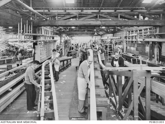 Factory employees working on the bottom boom which is being dressed on ...