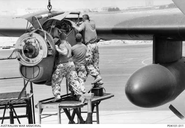 Three ground crew members from 36 Squadron RAAF complete maintenance on ...