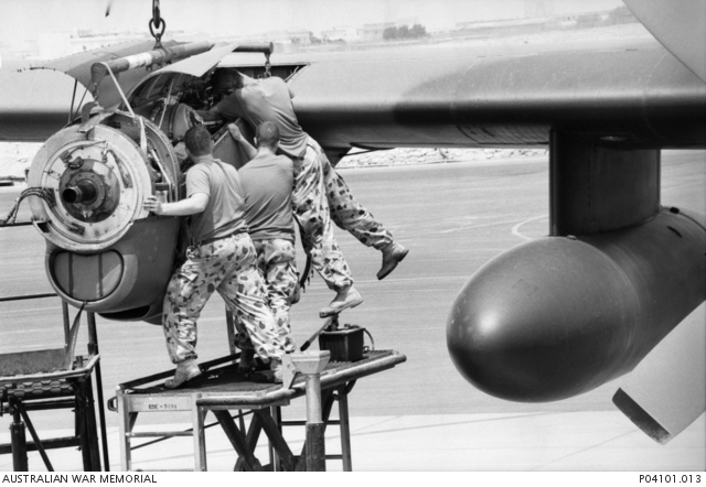 Three ground crew members from 36 Squadron RAAF complete maintenance on ...