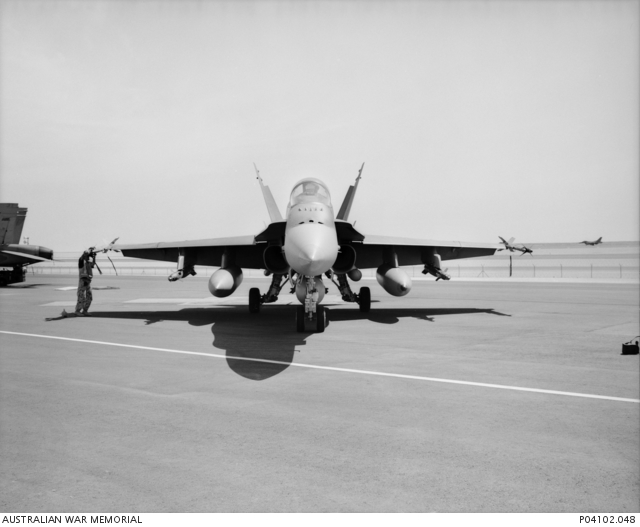 Ground crew from 75 Squadron RAAF inspect an F/A-18 Hornet aircraft ...