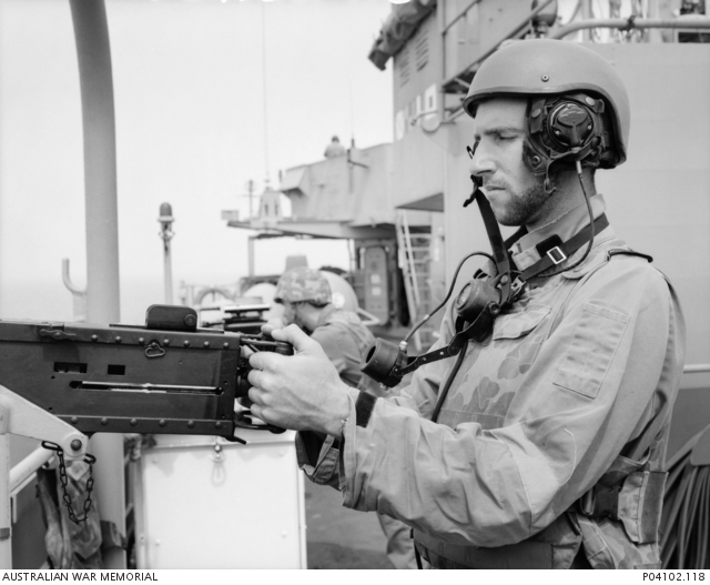 Two crew members of HMAS Kanimbla prepare to fire their weapons during ...