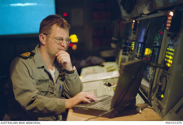 Lieutenant Commander Ivan Ingham works at a computer in Command Room ...