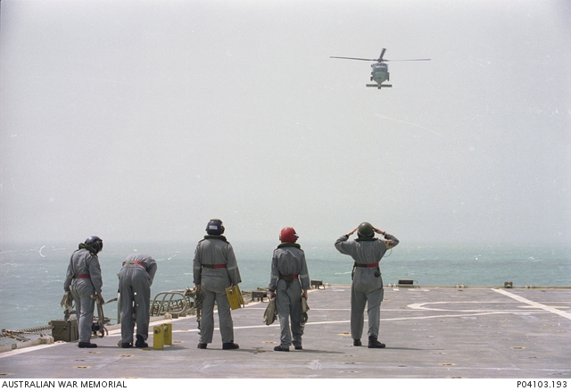 Five crew members of the HMAS Kanimbla wait the arrival on the ships ...
