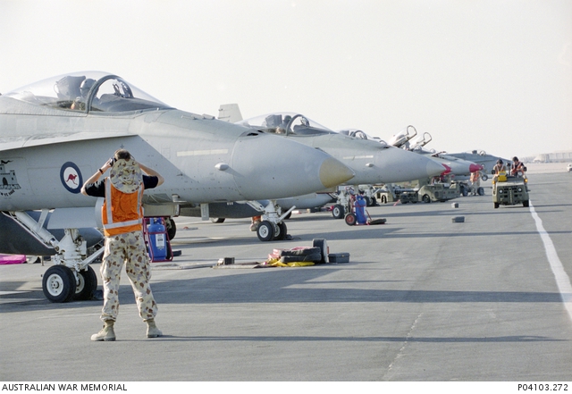 A 75 Squadron RAAF ground crew member signals to Flight Lieutenant ...