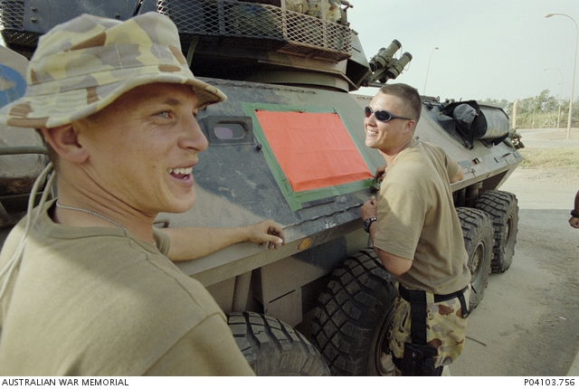 Australian Light Armoured Vehicle (ASLAV) crew members attach ...