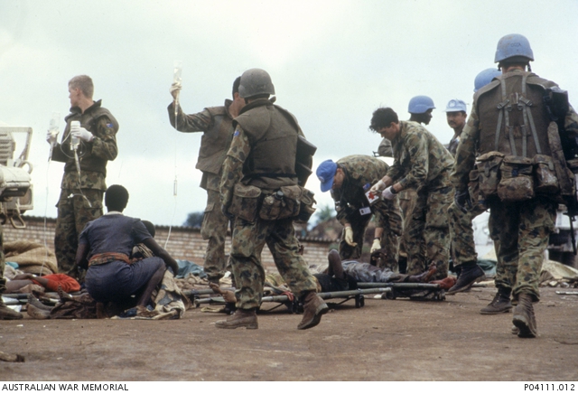 Soldiers from the UNAMIR II silhouetted against a setting sun treat ...