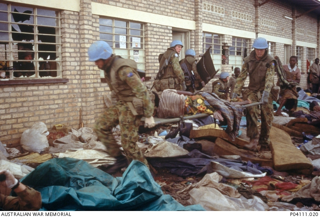 Two Australian soldiers carry a wounded Rwandan woman on a stretcher ...