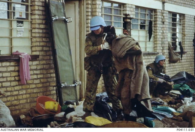 An Australian soldier assisting a seriously wounded Rwandan civilian ...