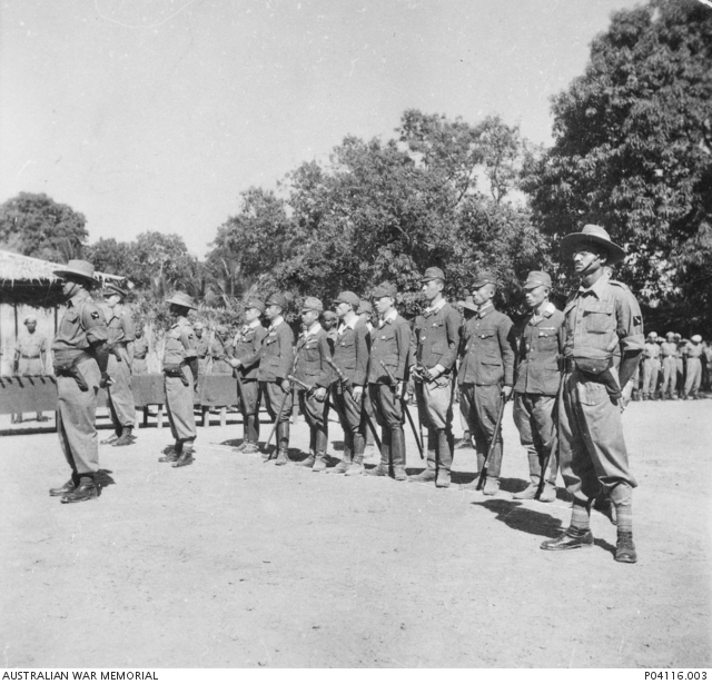 Eight Japanese officers wearing their swords, stand in a line, waiting ...