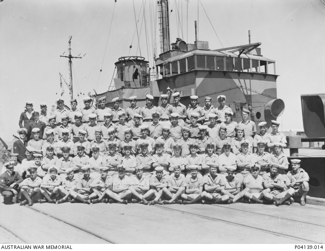 Crew of corvette HMAS Wallaroo, with ship in the background, its ...