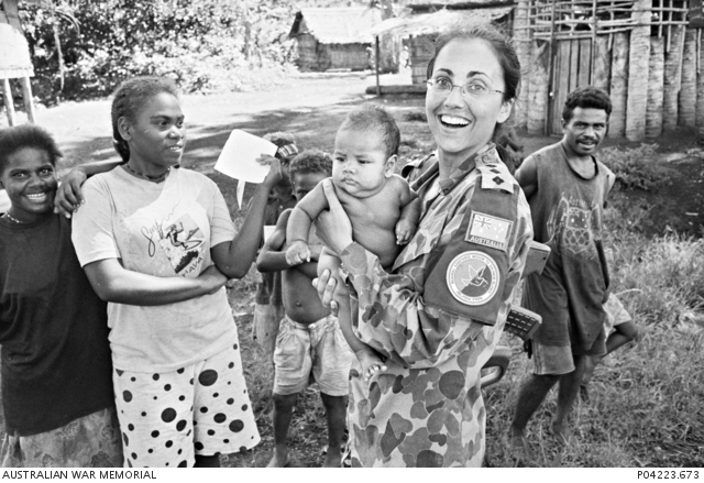 Captain Rachel Leal of 1st Intelligence Battalion holds a baby on a ...