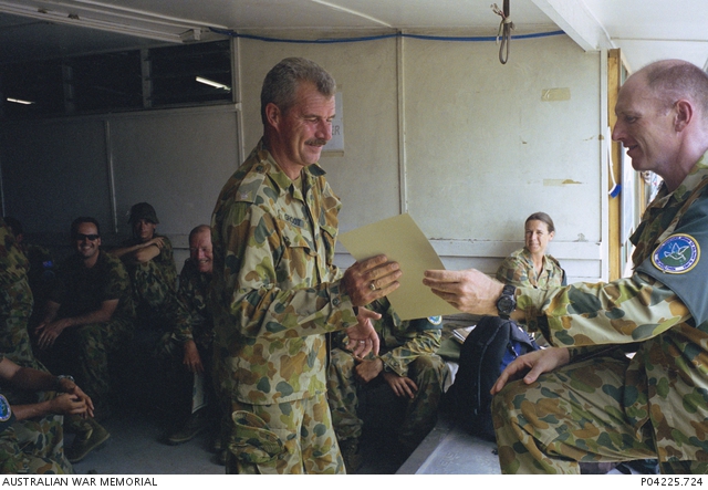 Major Groot, an Australian army officer, receives a certificate from ...