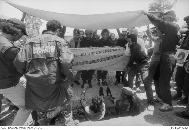 Members of the Aitarak pro-Indonesian militia lower the coffin of one ...