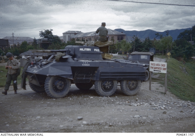 A US Army M20 Military Police (MP) armoured car and MPs at a check ...