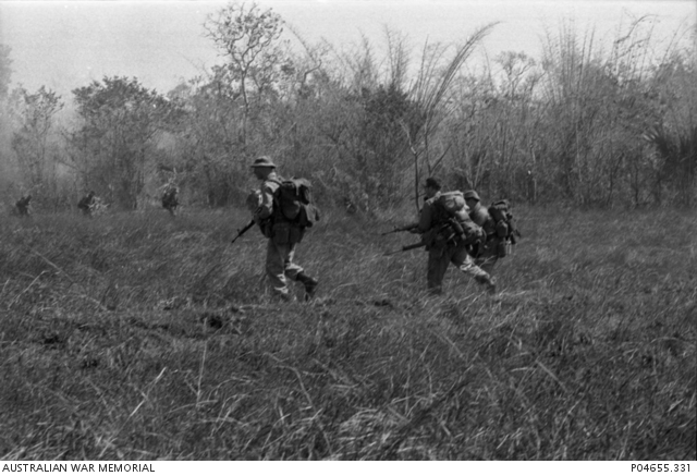 With their SLR rifles at the ready, members of A Company, 7RAR, hurry ...