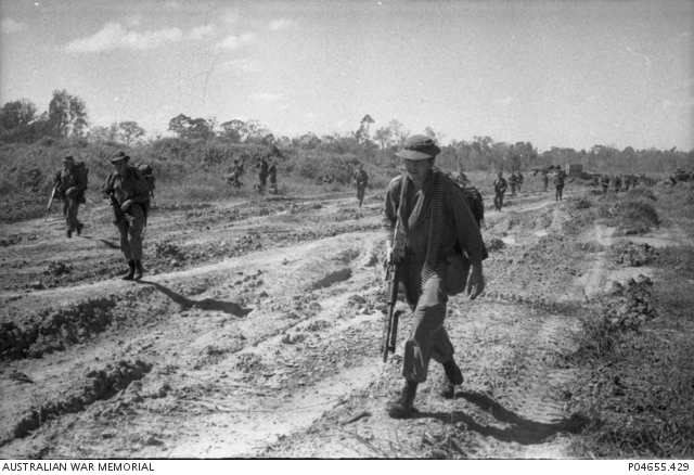Members of 7RAR make their way along a wide cleared track during an ...