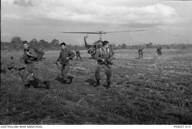 Members of D Company, 6RAR, scatter towards cover as they disembark ...