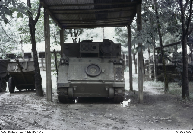 An M577A1 armoured communications vehicle parked under an improvised ...