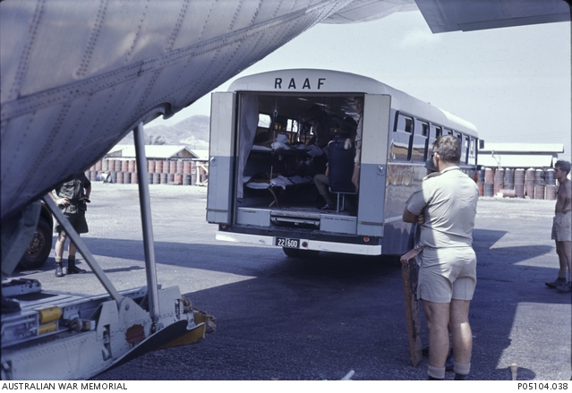 A RAAF transport bus backs into a C-130 Hercules aircraft rear loading ...